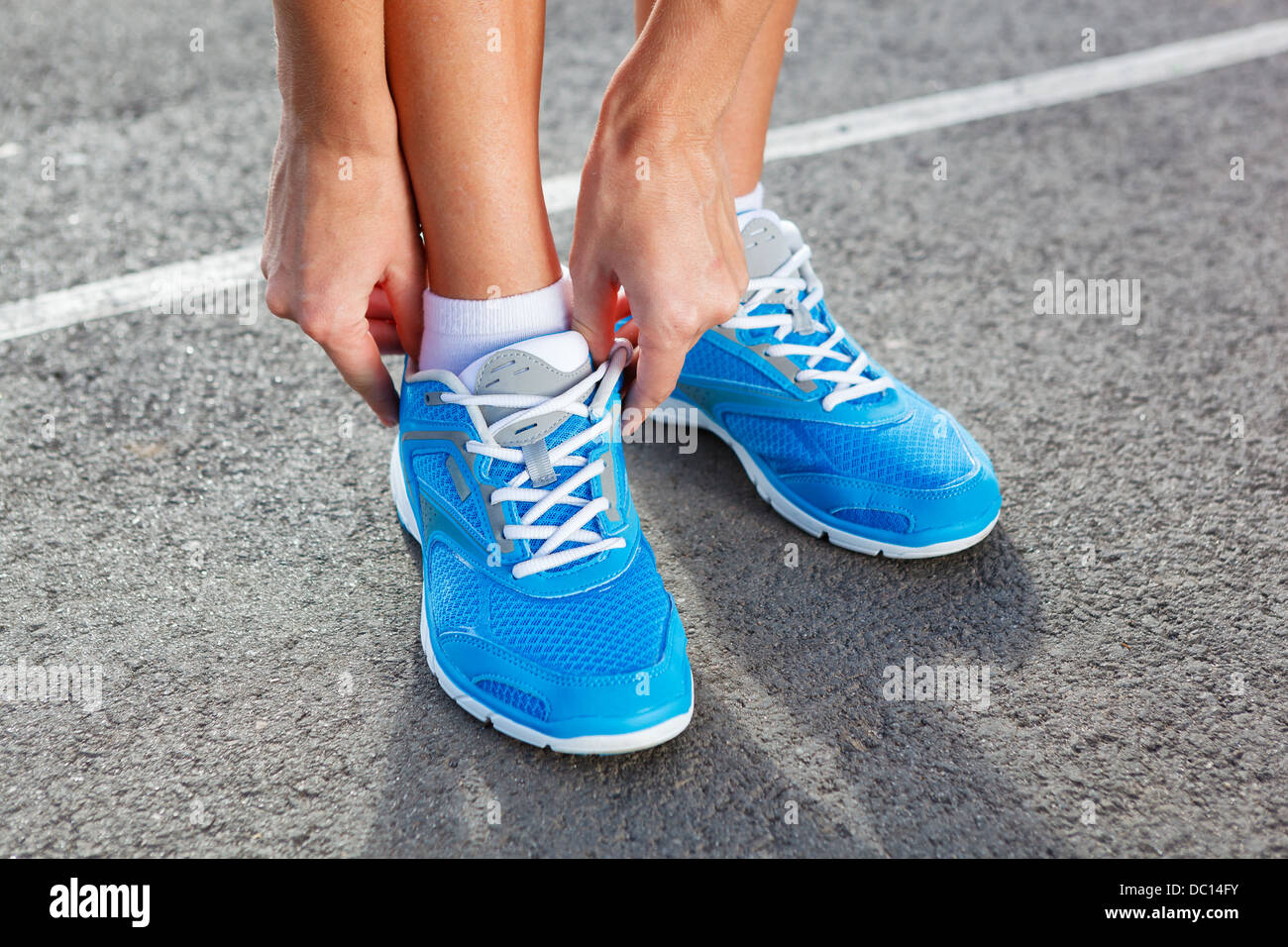 Woman tying her shoe hi-res stock photography and images - Alamy