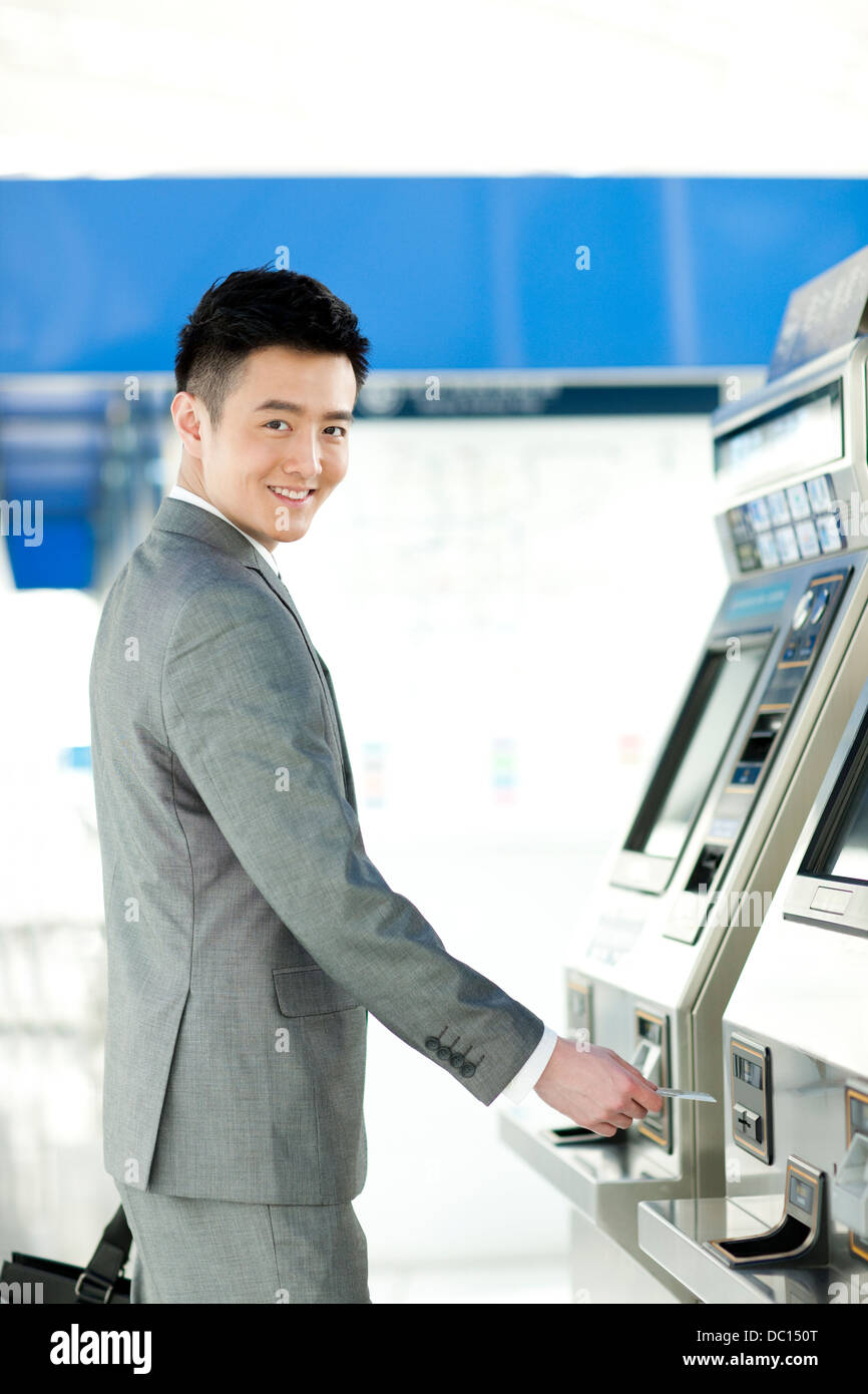 Young businessman using automatic ticket machine at subway station ...