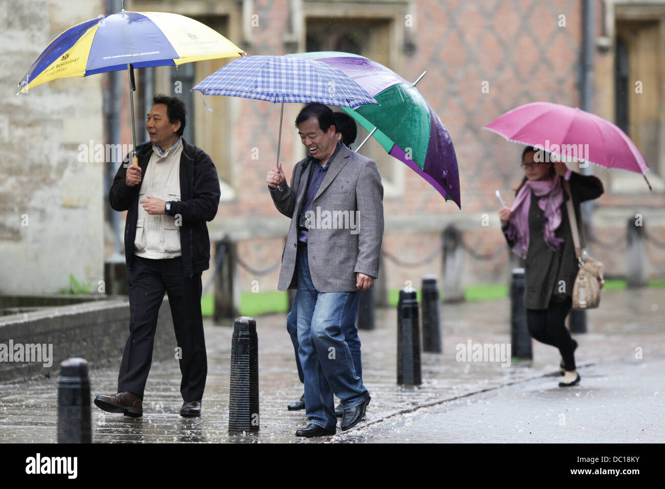 TOURISTS UNDER UMBRELLAS IN THE RAIN IN CAMBRIDGE Stock Photo - Alamy