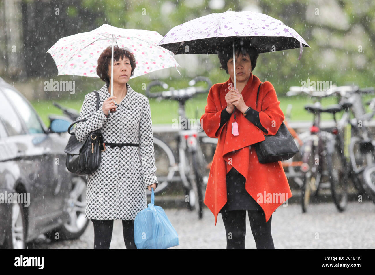 TOURISTS UNDER UMBRELLAS IN THE RAIN IN CAMBRIDGE Stock Photo - Alamy