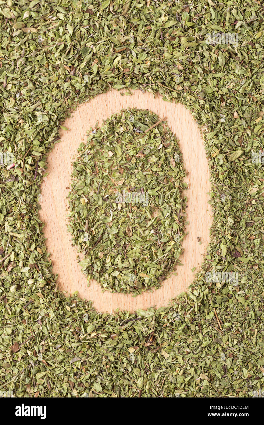 Letter O written with oregano on wooden table Stock Photo - Alamy