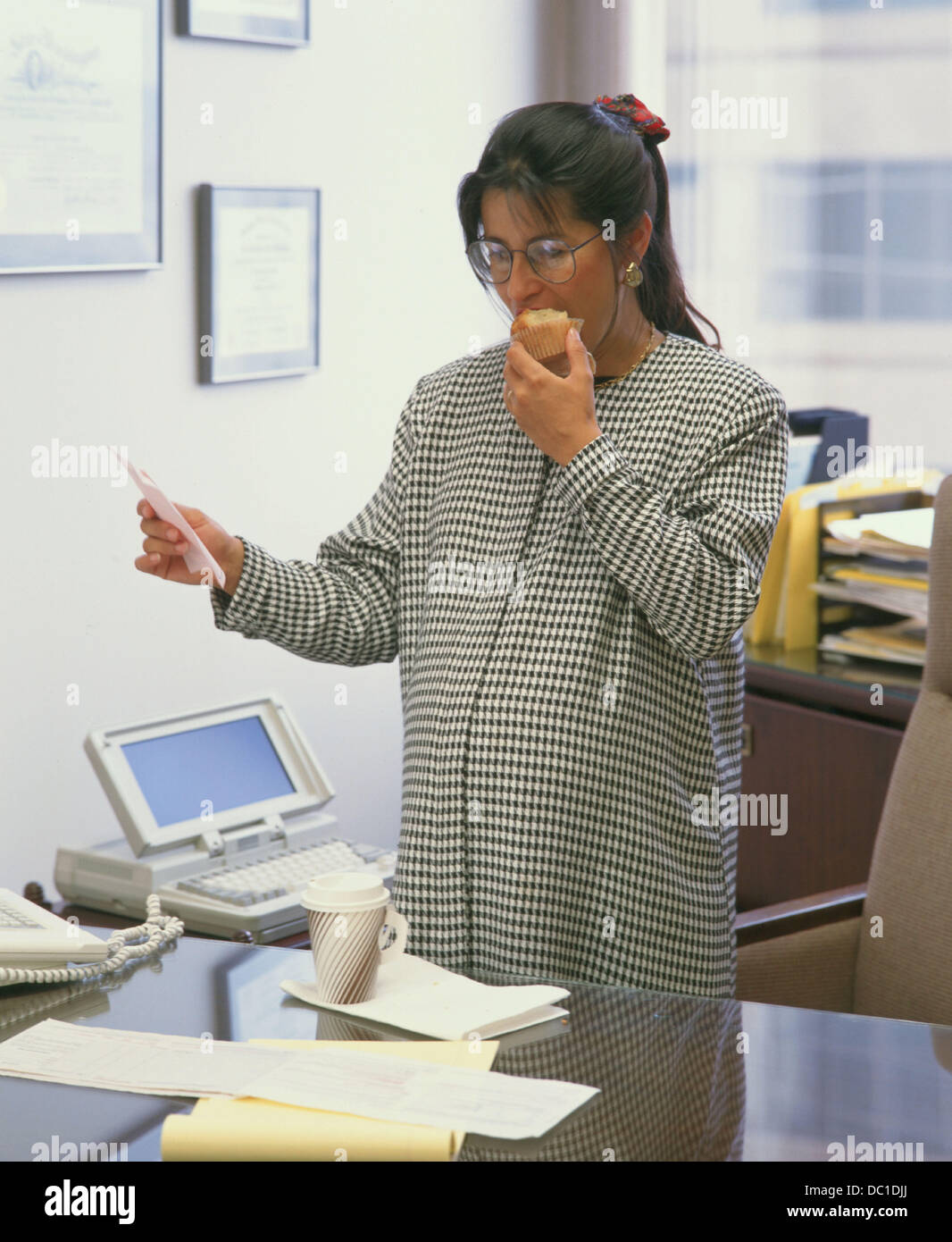 Pregnant Hispanic attorney enjoying a healthy snack at her desk Stock ...