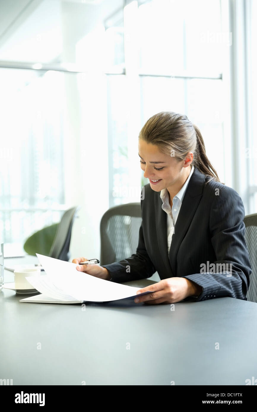 Businesswoman reading paperwork in conference room Stock Photo - Alamy