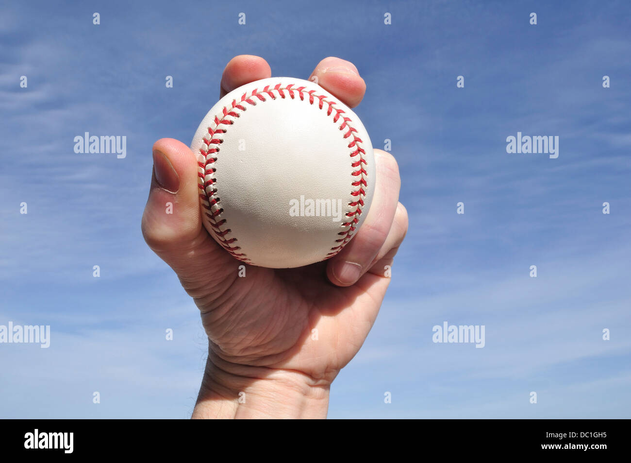 Player Gripping a New Baseball Against a Blue Sky Stock Photo - Alamy