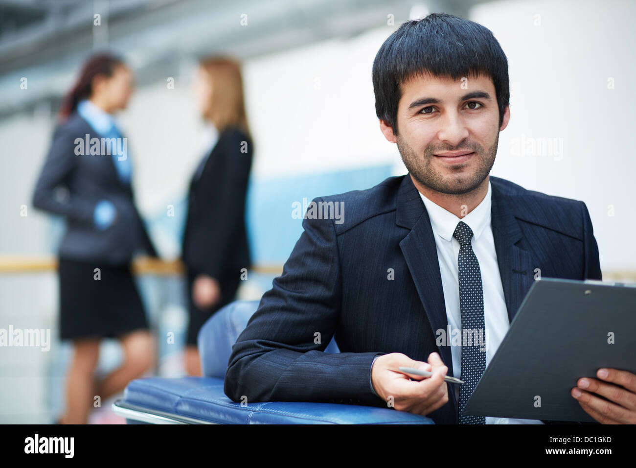 Portrait of friendly male leader looking at camera in working ...