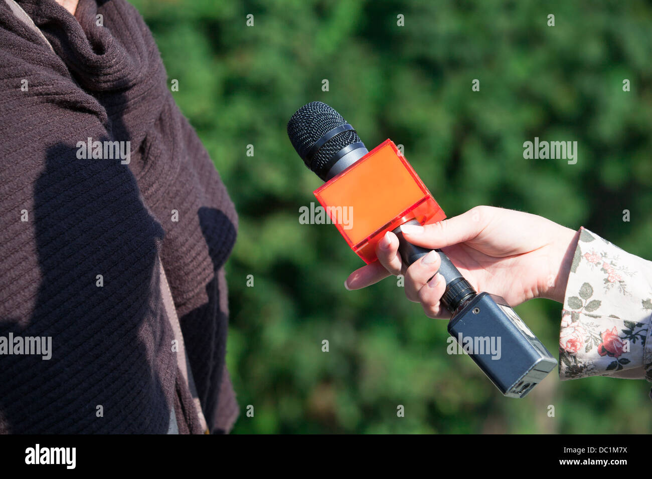 A journalist is making a interview with a microphone Stock Photo - Alamy