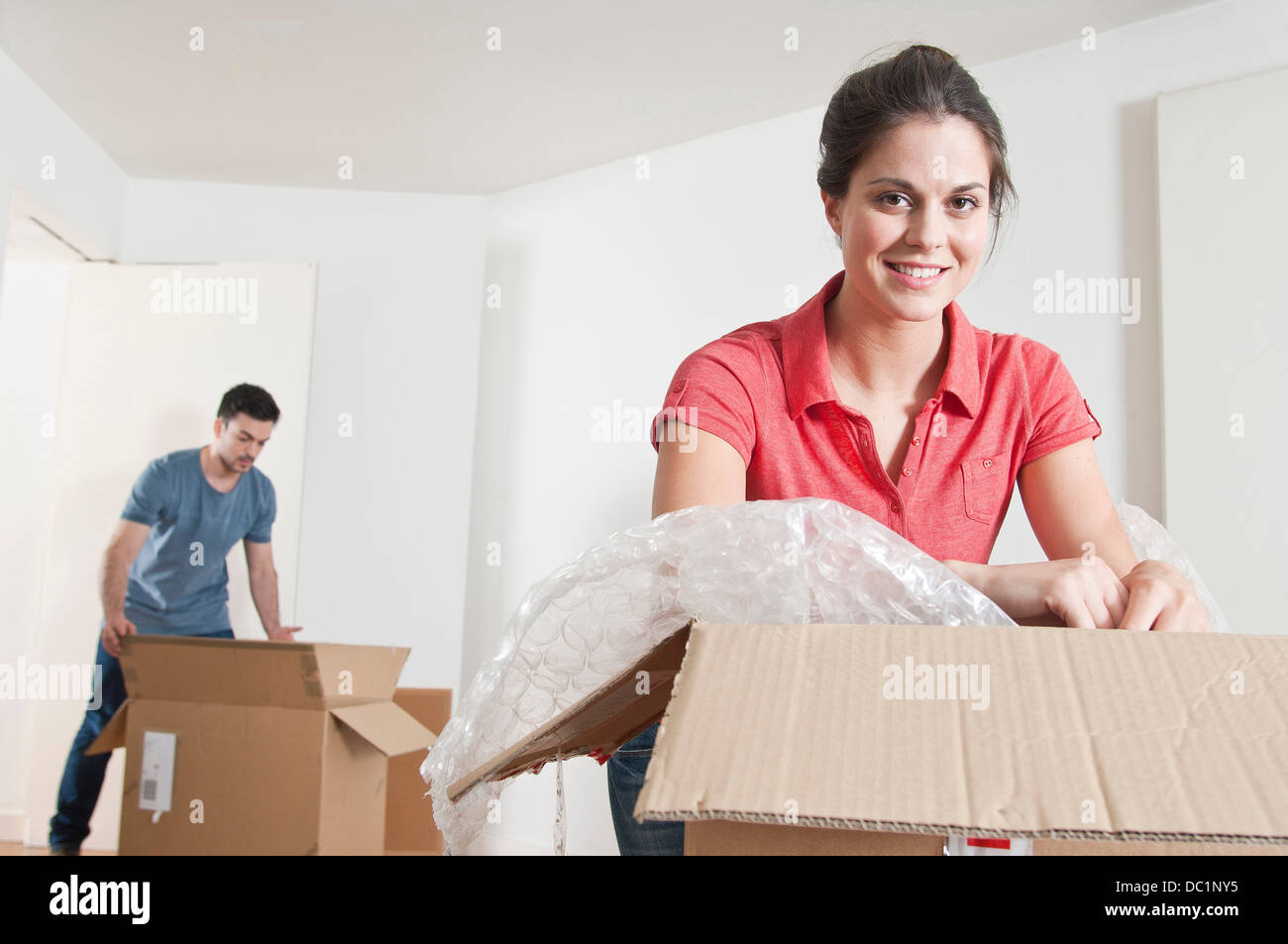 Young couple unpacking cardboard boxes Stock Photo - Alamy