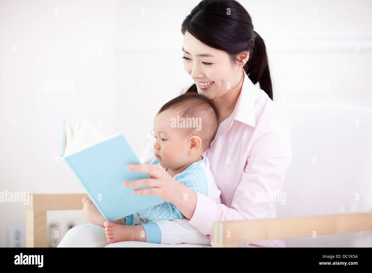 mother reading a book to baby Stock Photo - Alamy