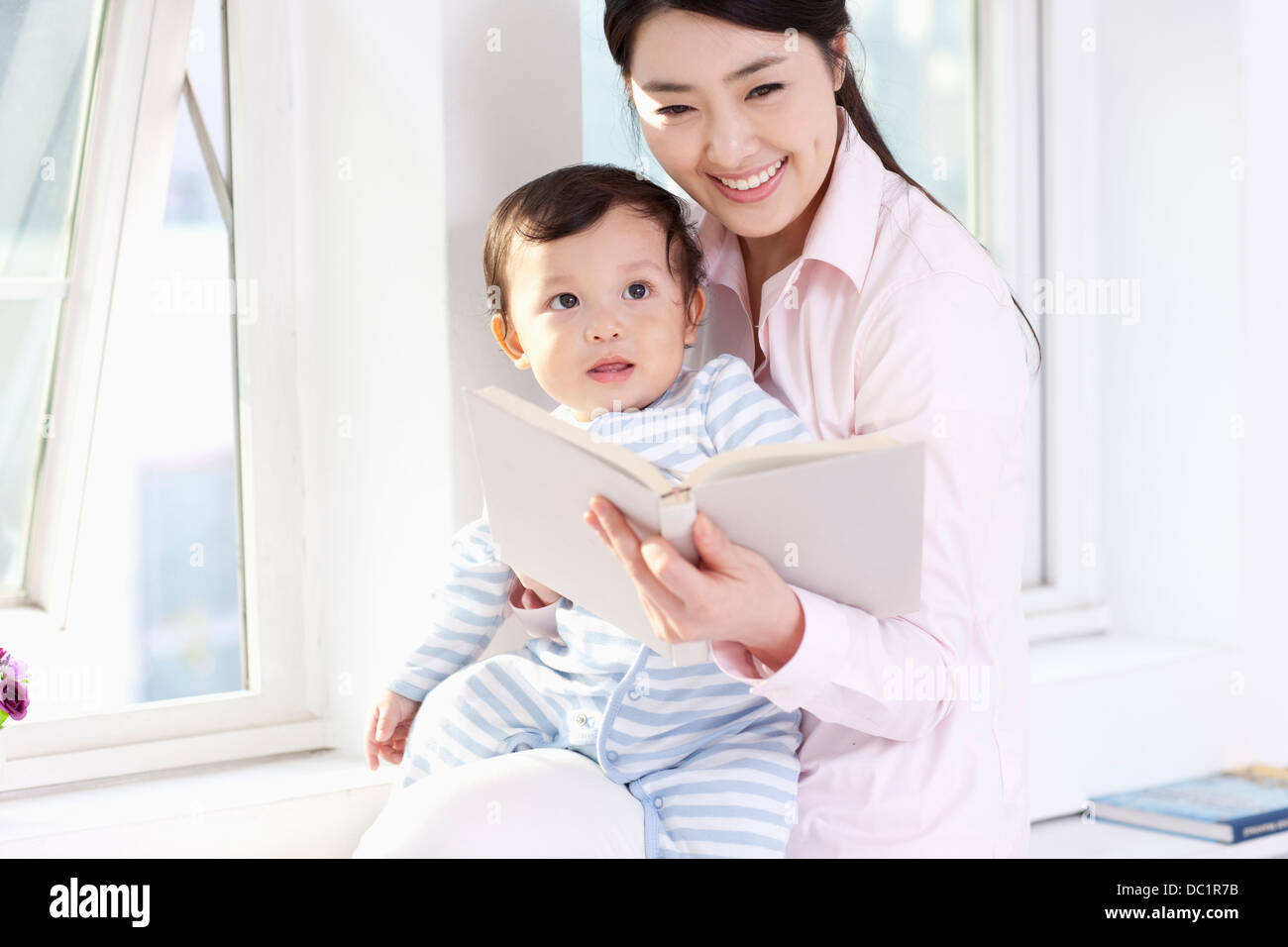 mother reading a book to baby Stock Photo - Alamy