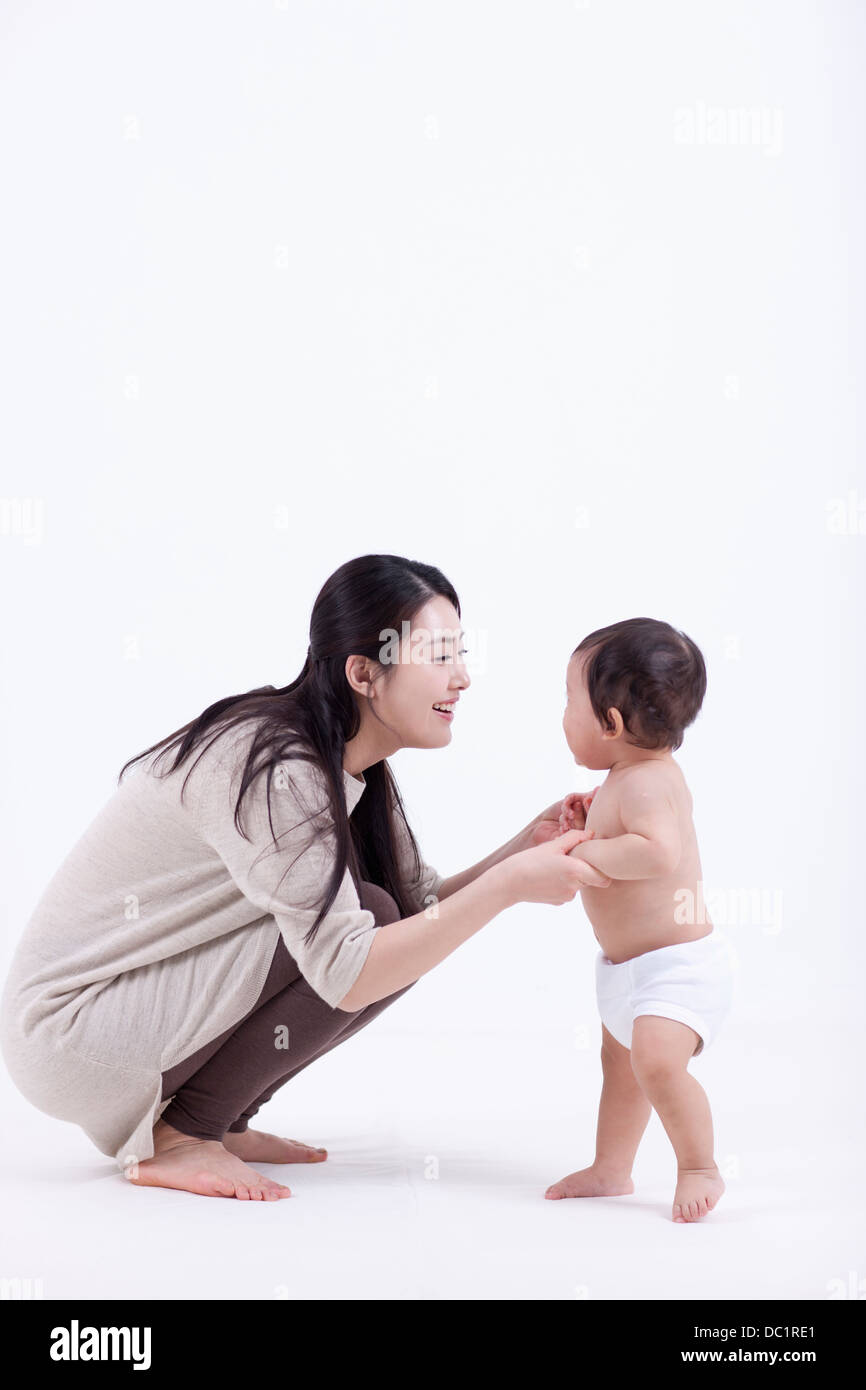 mother teaching baby how to walk Stock Photo - Alamy