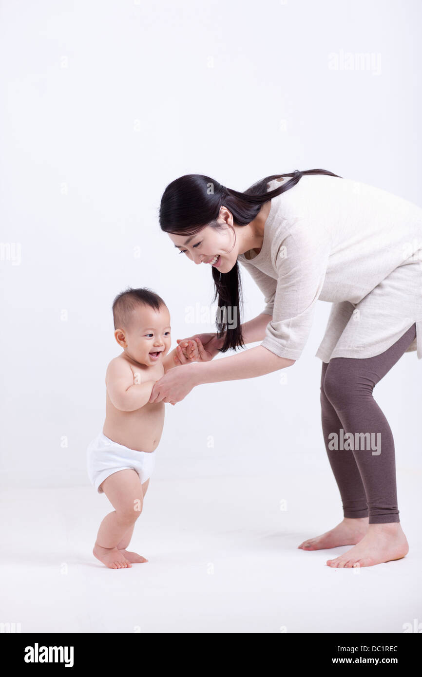mother teaching baby how to walk Stock Photo - Alamy