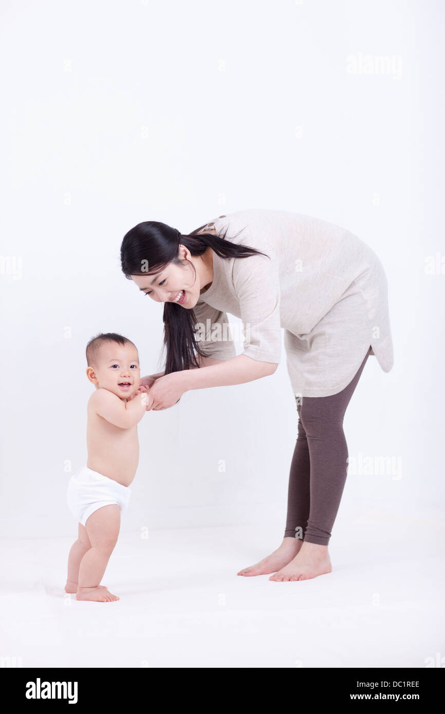 mother teaching baby how to walk Stock Photo - Alamy