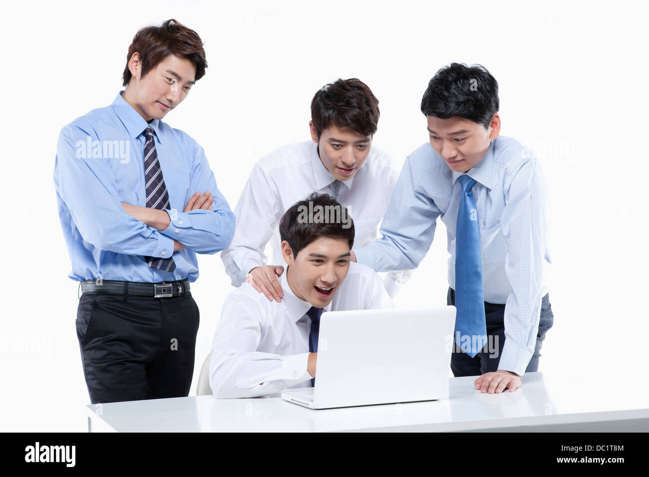 businessmen talking while standing around a colleague Stock Photo - Alamy
