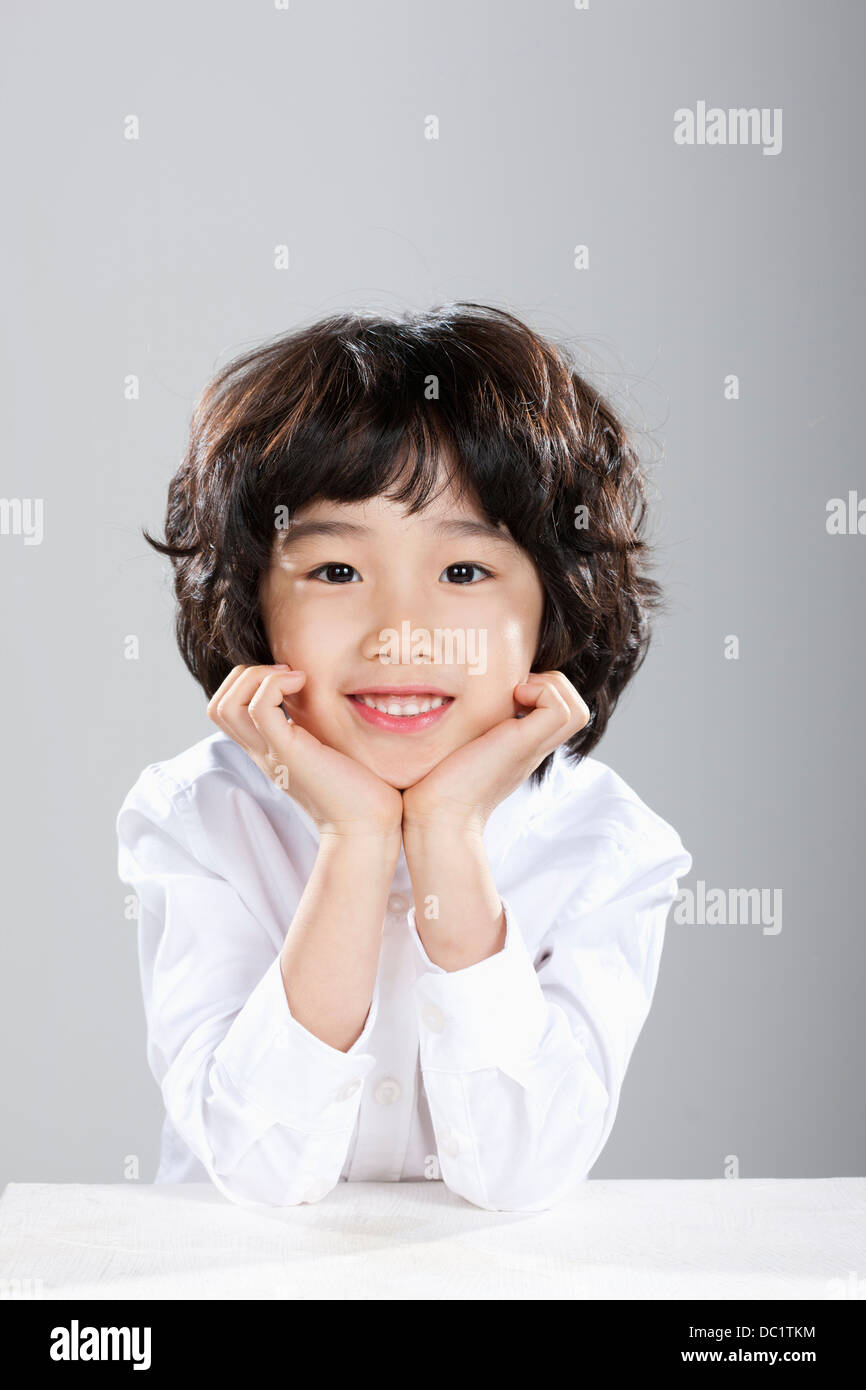 a boy leaning his chin on hands Stock Photo - Alamy