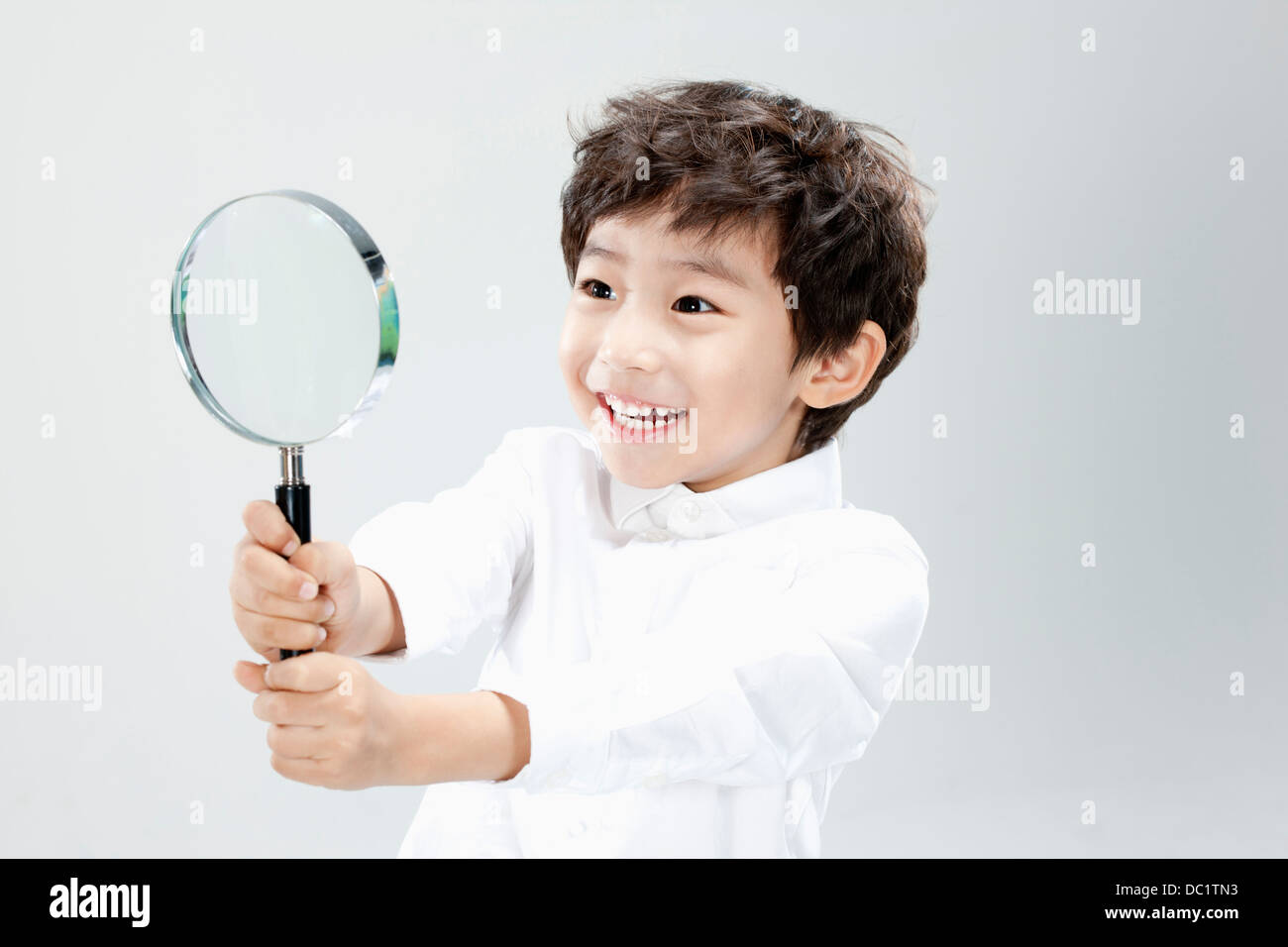 a boy playing with magnifier Stock Photo - Alamy