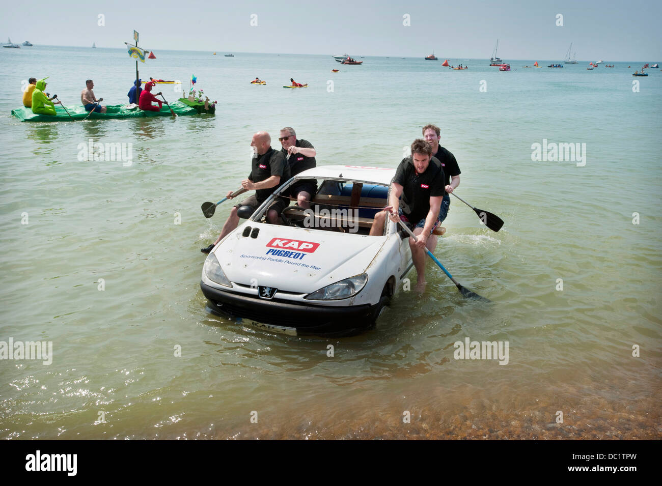 Four men rowing a car ashore after competing in Brighton's Paddle Round ...