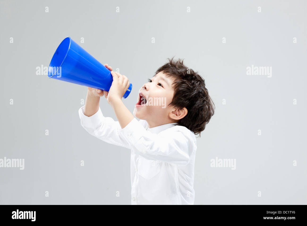 a boy shouting at blue megaphone Stock Photo - Alamy