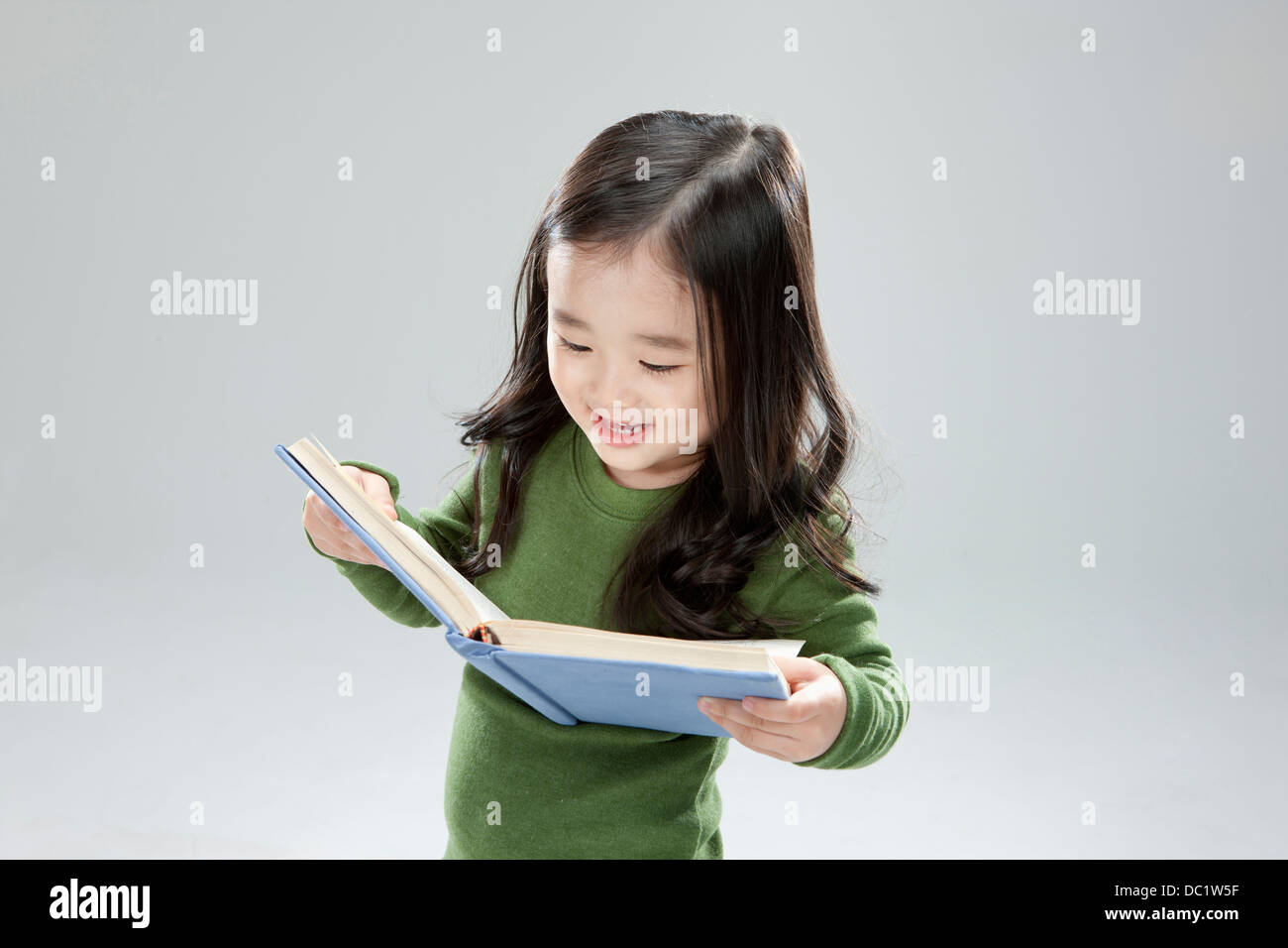 a girl reading a book while standing Stock Photo - Alamy