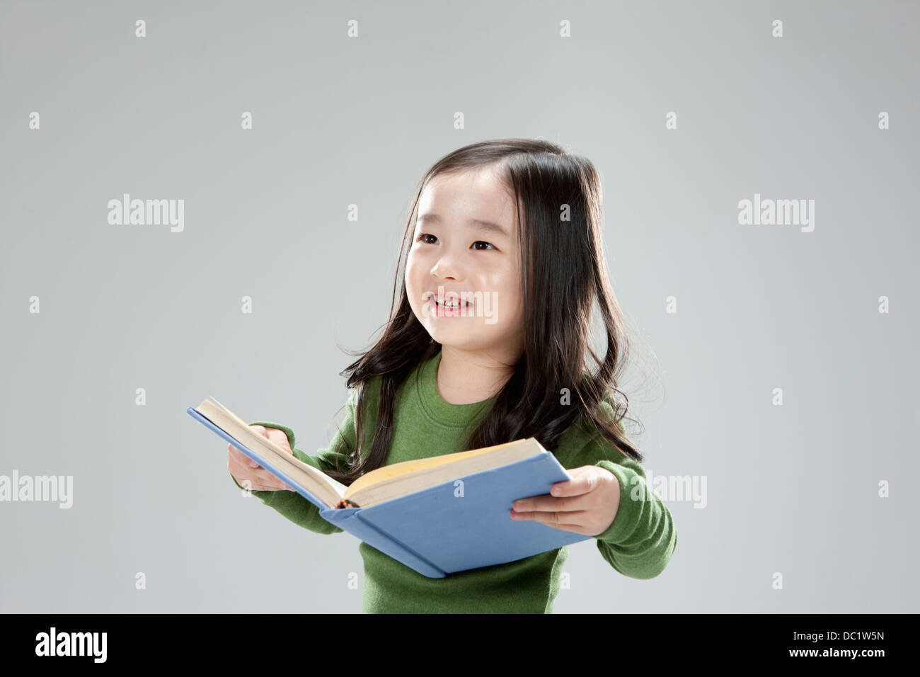 a girl reading a book while standing Stock Photo - Alamy