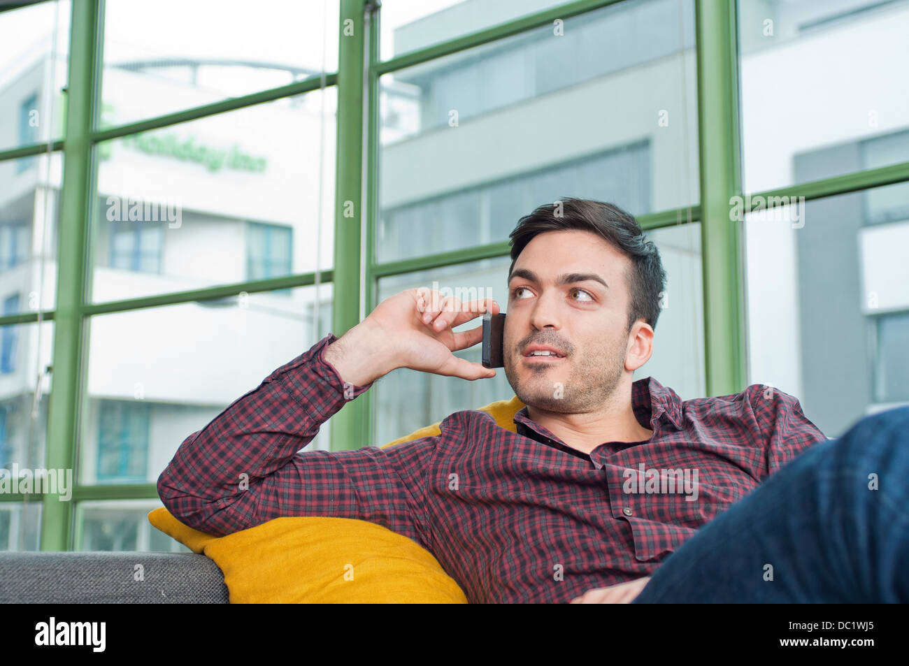 Young man at home using his mobile phone Stock Photo - Alamy