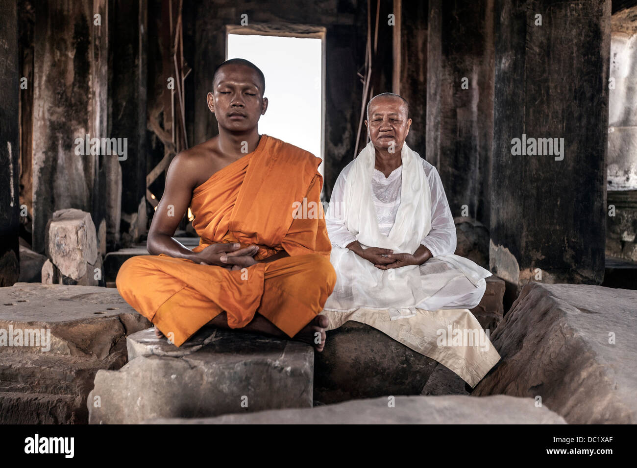 Senior and young monk meditating in temple in Angkor Wat, Siem Reap ...