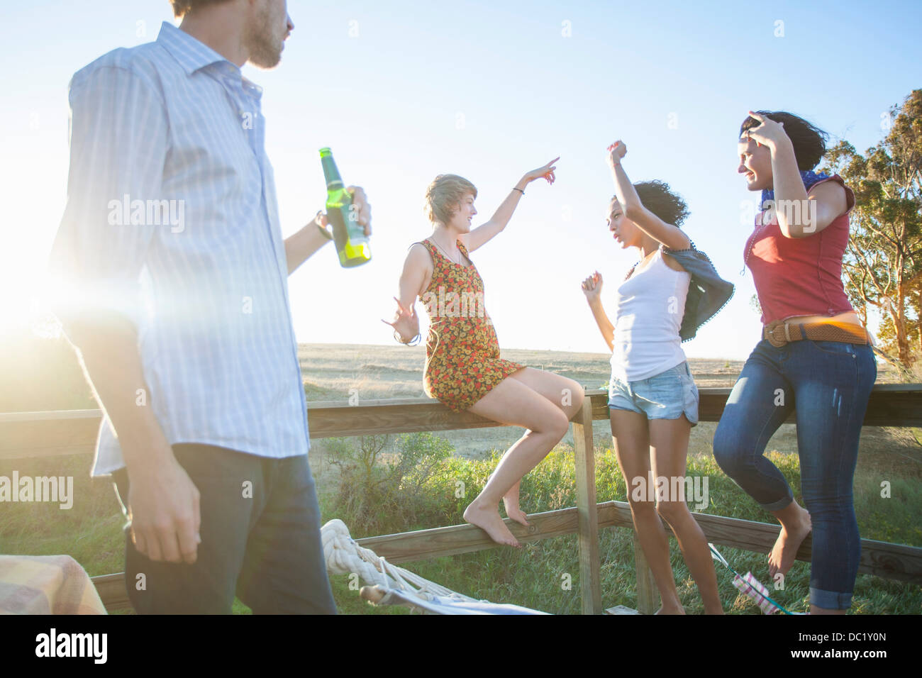 Young man watching friends dance on balcony Stock Photo - Alamy