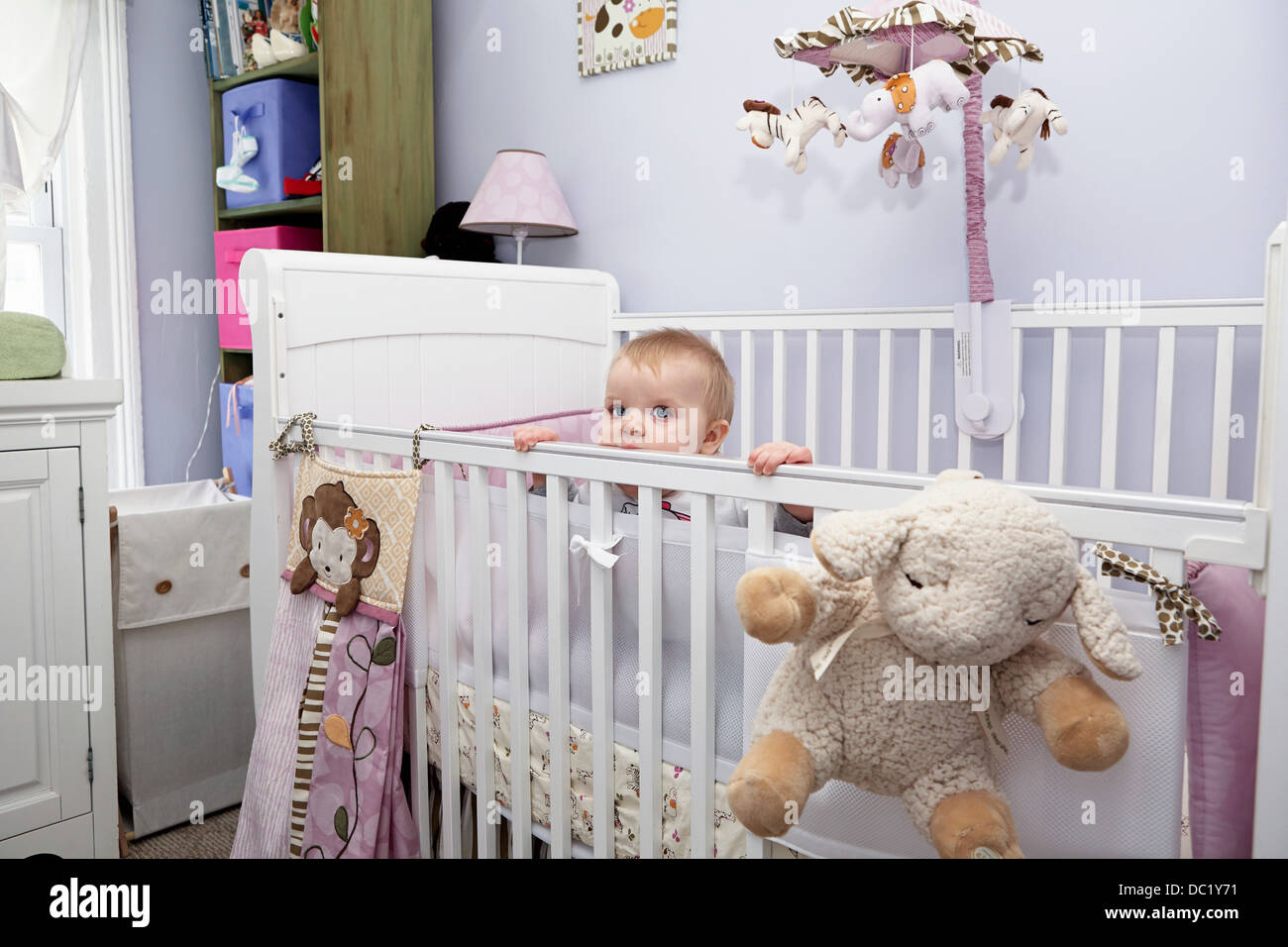 Girl peering over cot railings nursery hi-res stock photography and ...