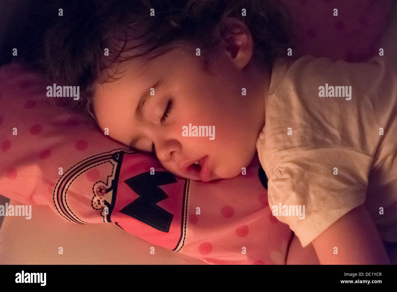 A sleeping girl child in dim lighting Stock Photo - Alamy