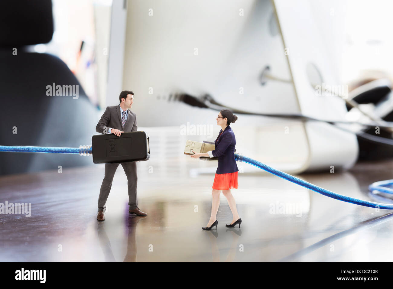 Office colleagues holding large computer cables on oversized desk Stock ...