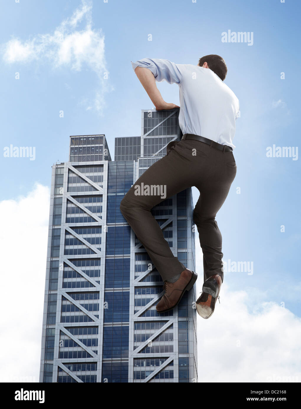 Oversized businessman climbing skyscraper, low angle view Stock Photo ...