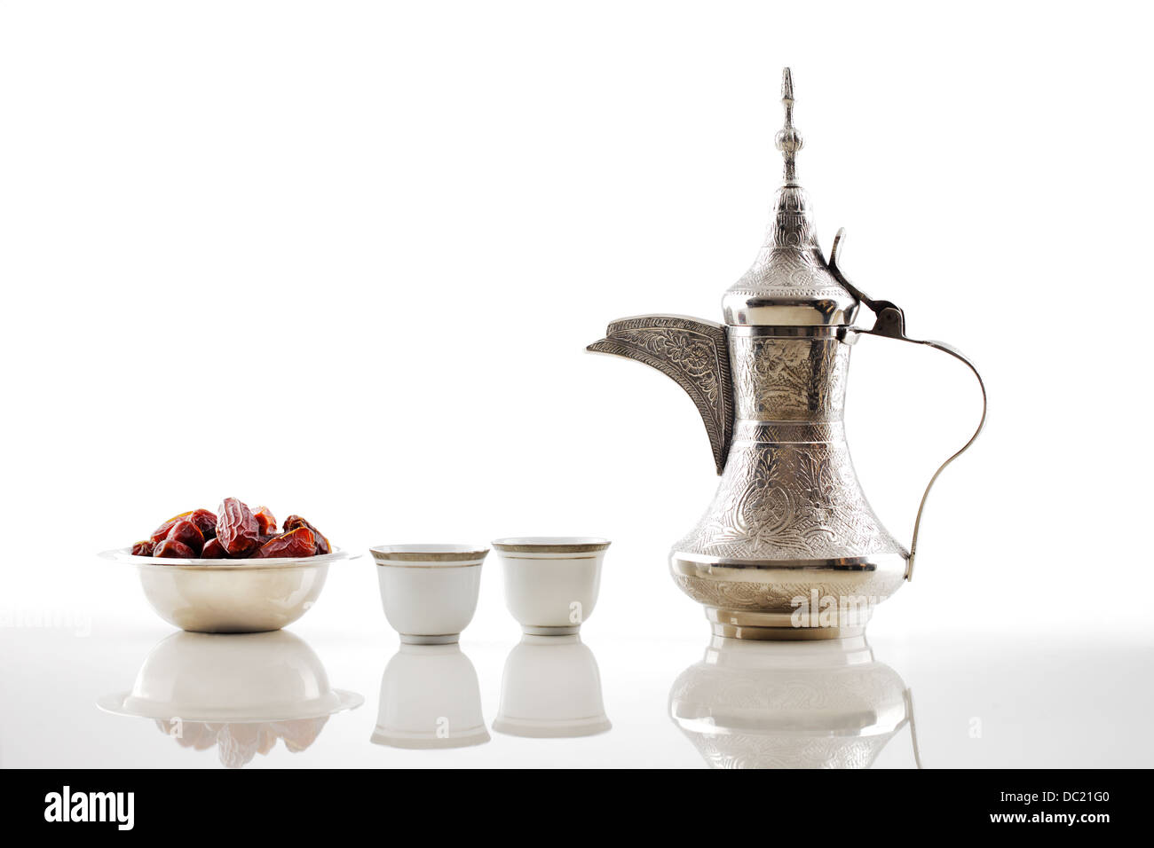 A dallah, a metal pot for making Arabic coffee with a bowl of dried ...