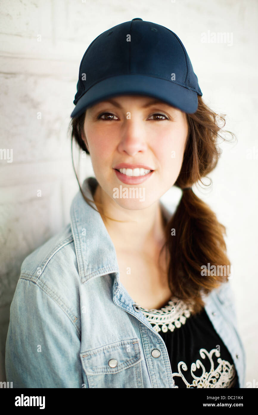 Mid adult woman wearing cap and smiling, portrait Stock Photo - Alamy