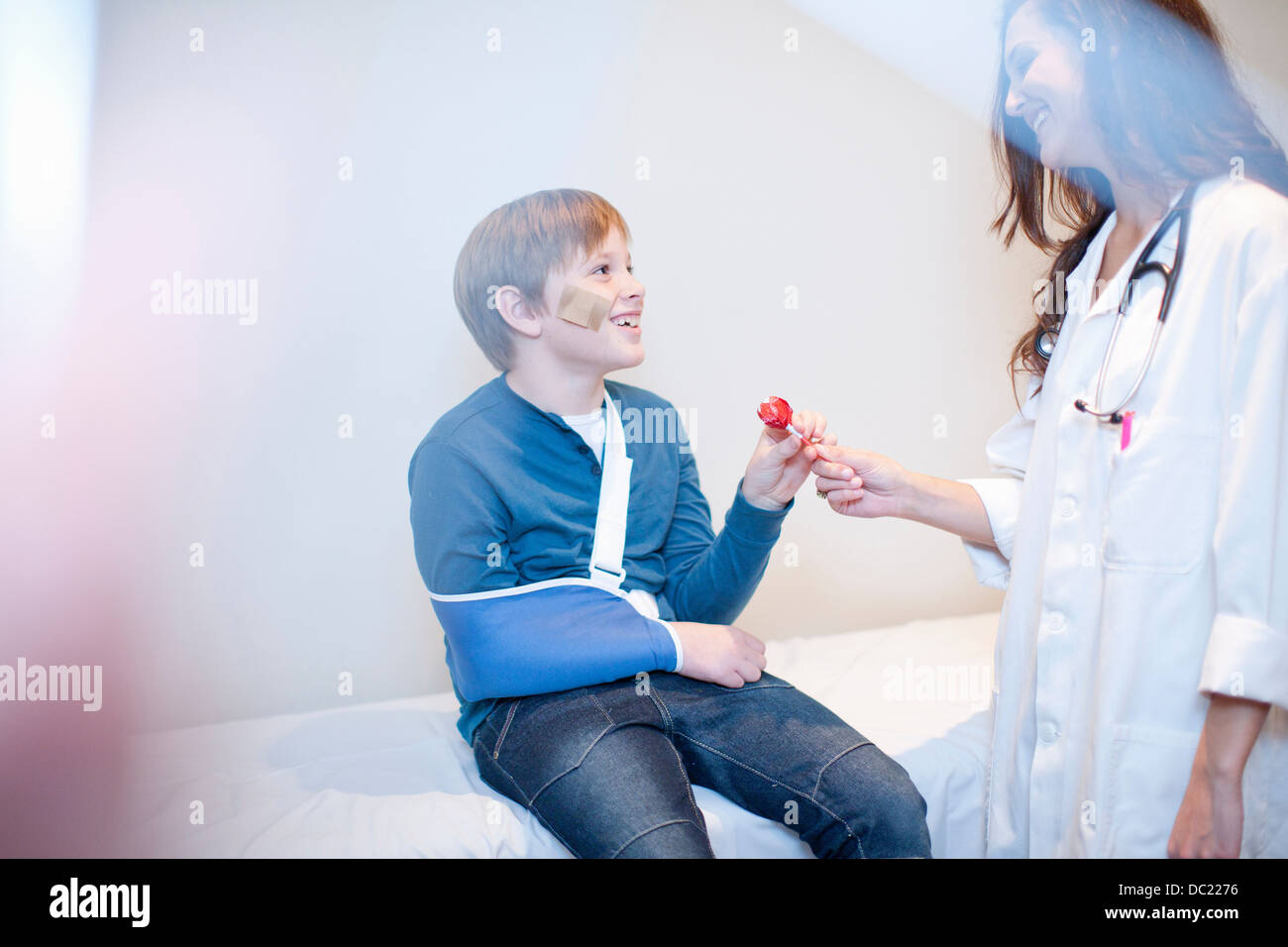 Doctor giving young boy a lollipop Stock Photo - Alamy