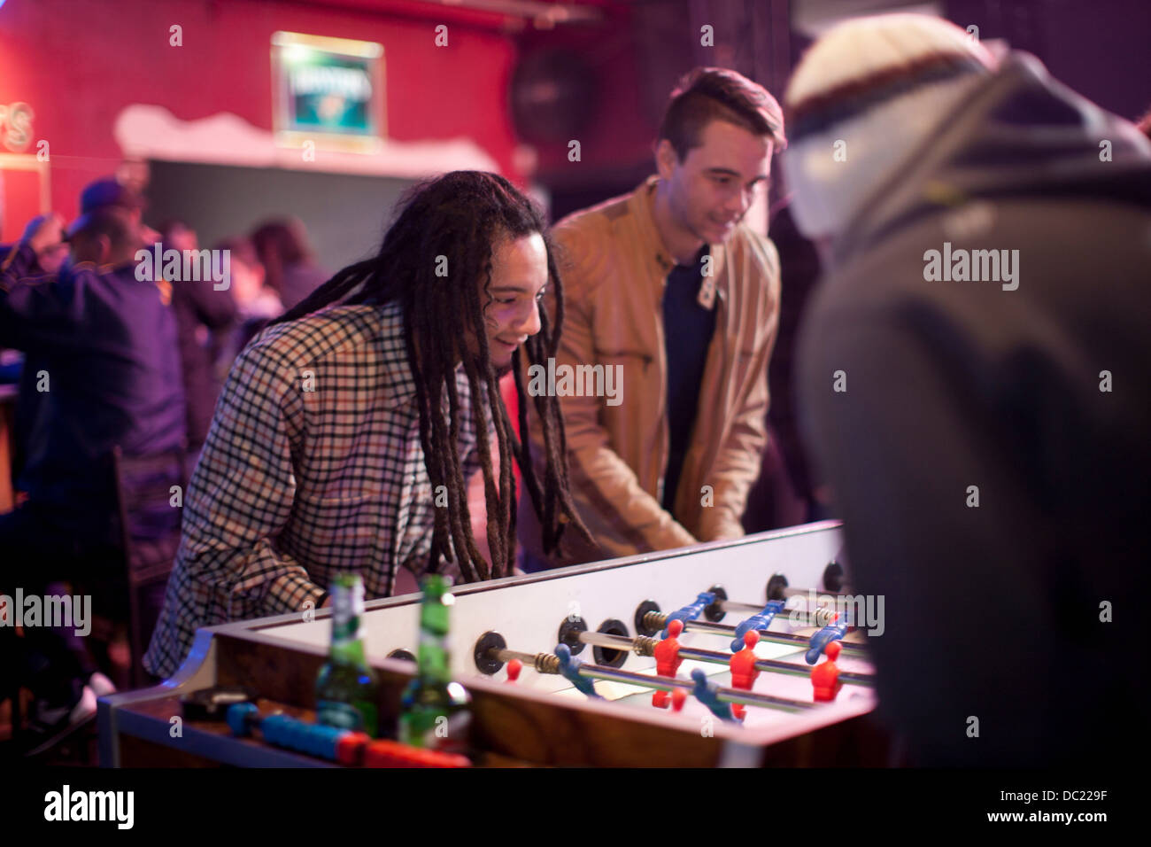 Group of men playing table football in bar Stock Photo - Alamy