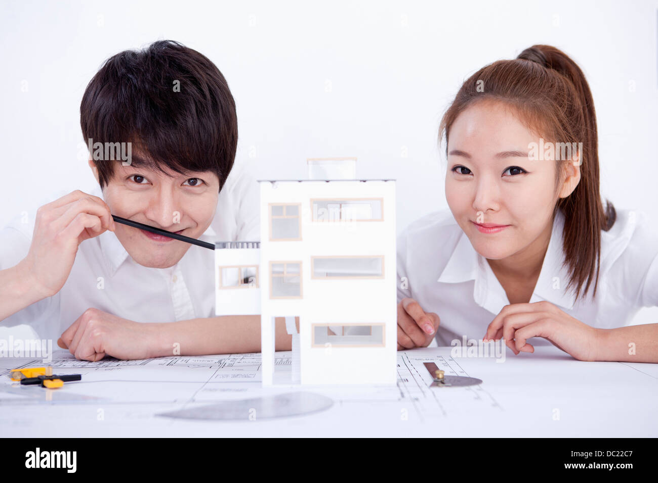 interior designers looking at small building model together Stock Photo ...