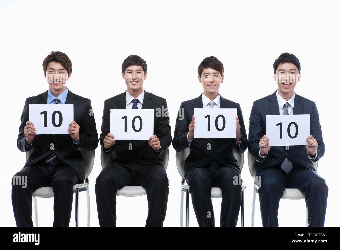 businessmen sitting on chairs in a line holding number 10 score Stock ...