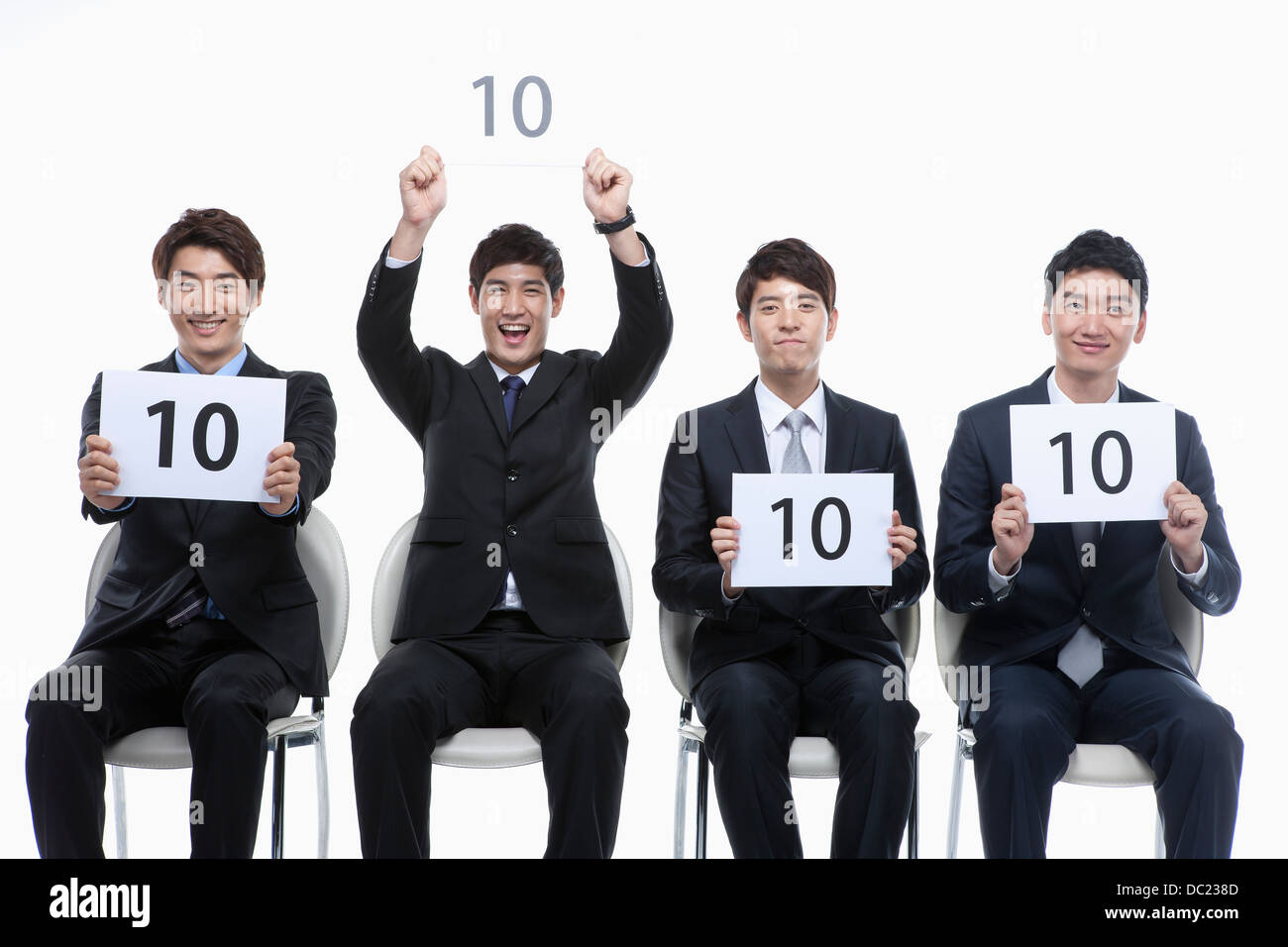 businessmen sitting on chairs in a line holding number 10 score Stock ...