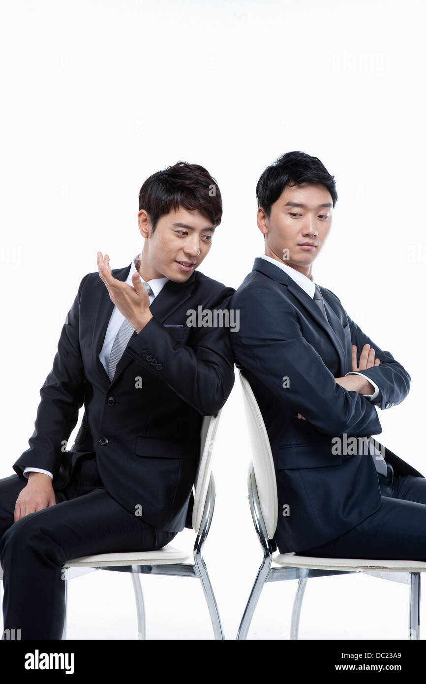 businessmen sitting back to back Stock Photo - Alamy