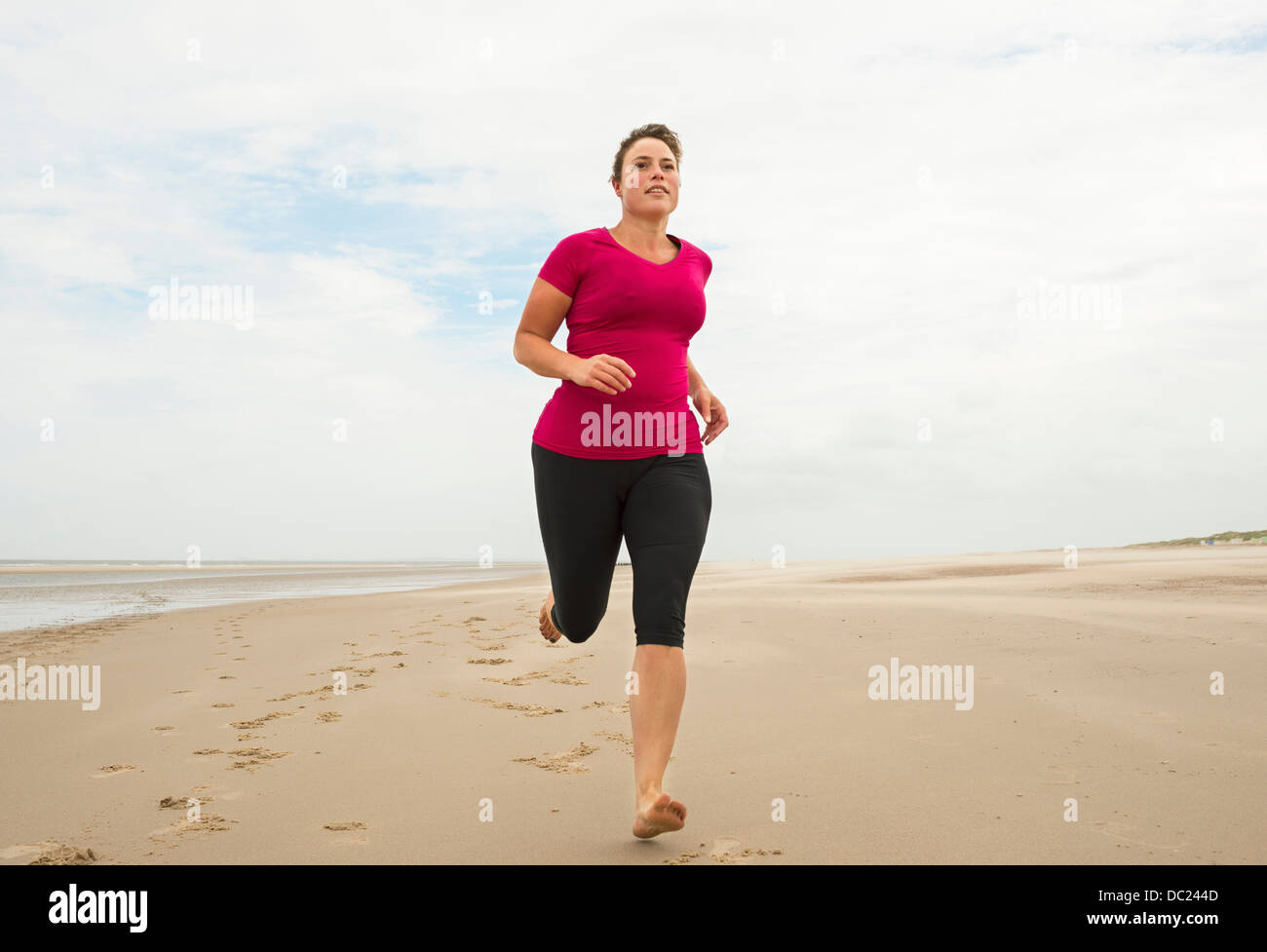 Person jogging on beach hi-res stock photography and images - Alamy