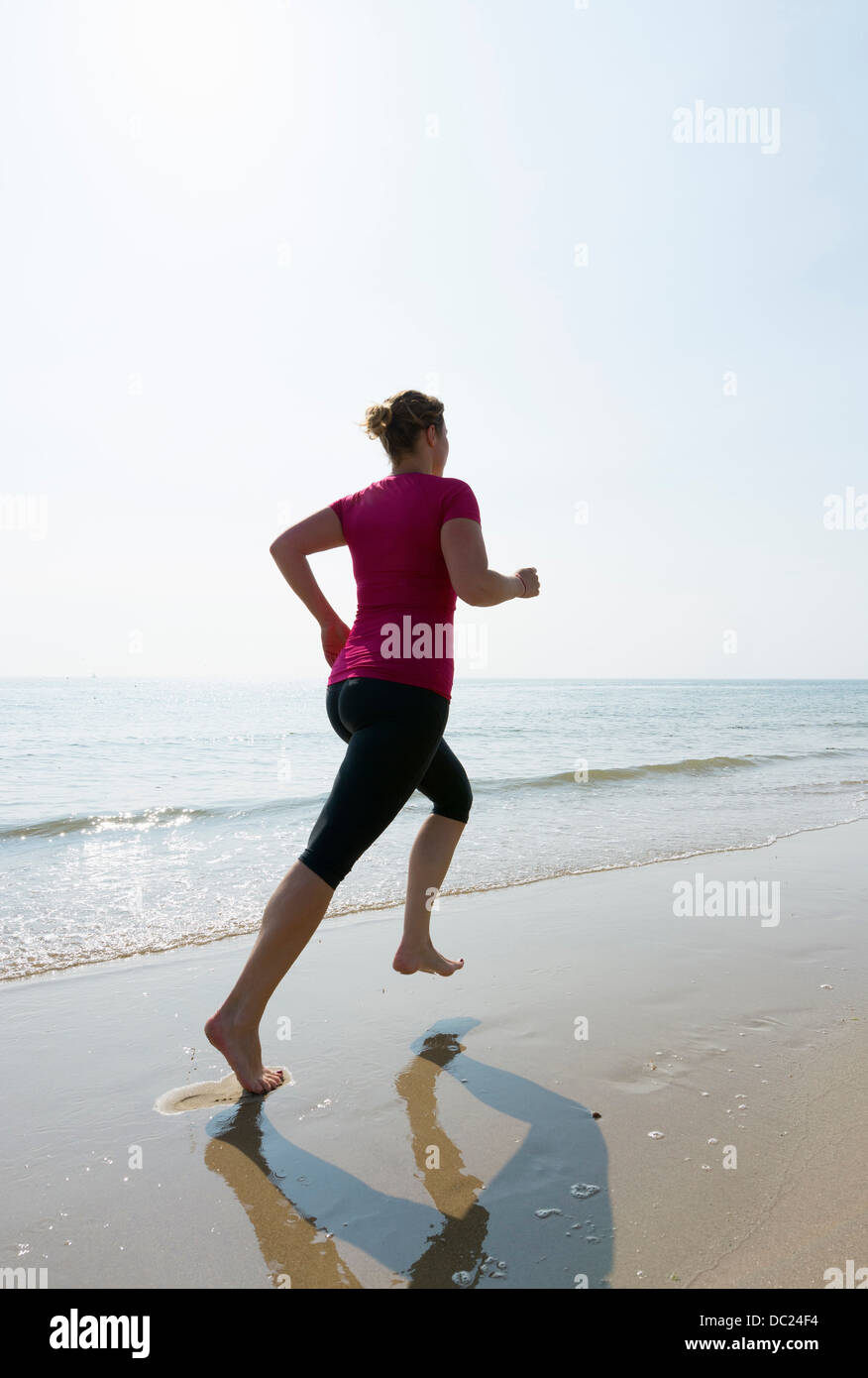 Woman running beach beach hi-res stock photography and images - Alamy