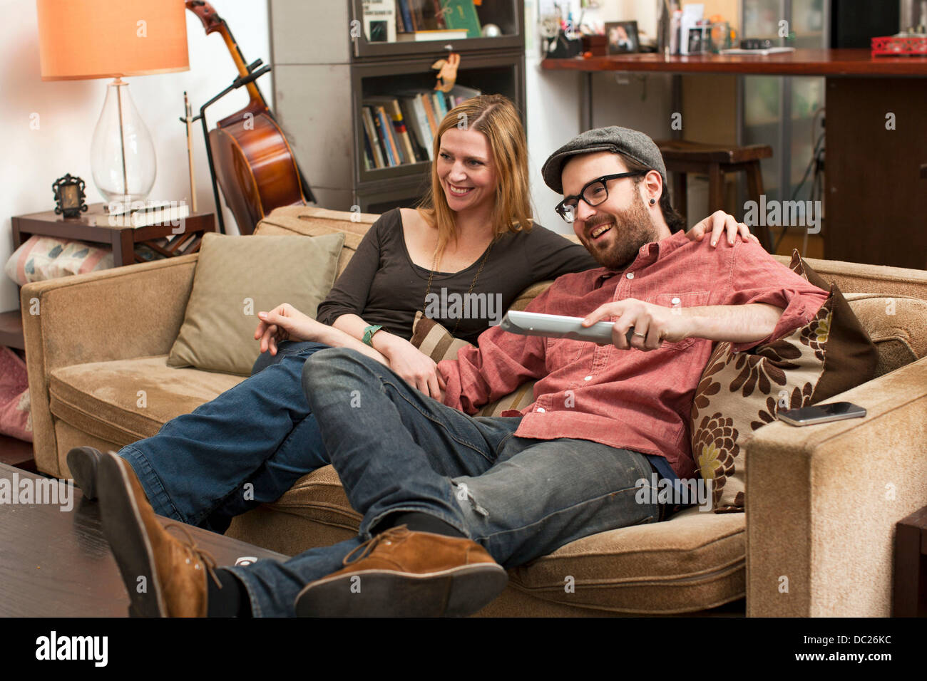 Couple sitting on sofa watching television Stock Photo - Alamy