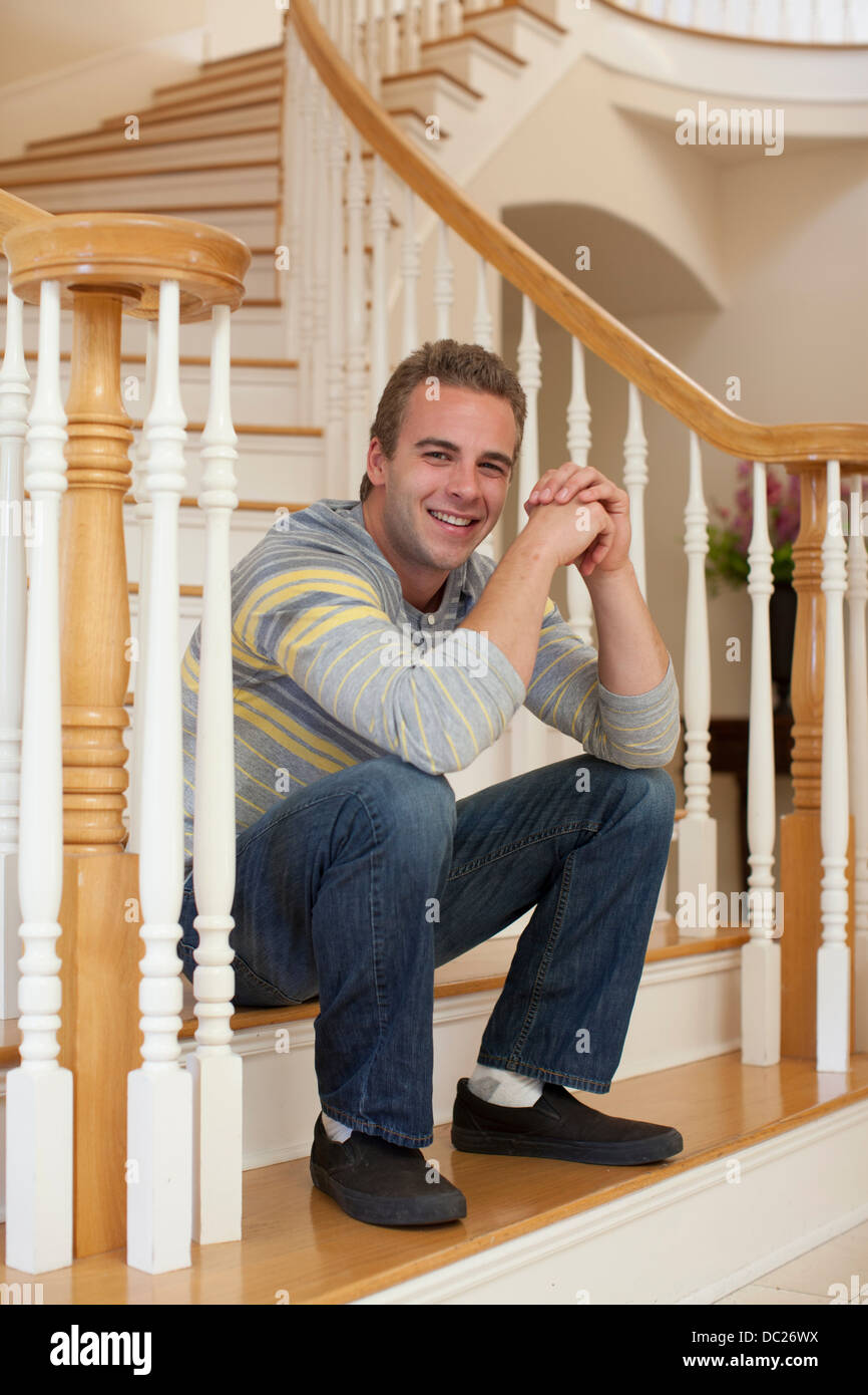 Young man sitting on stairs Stock Photo - Alamy