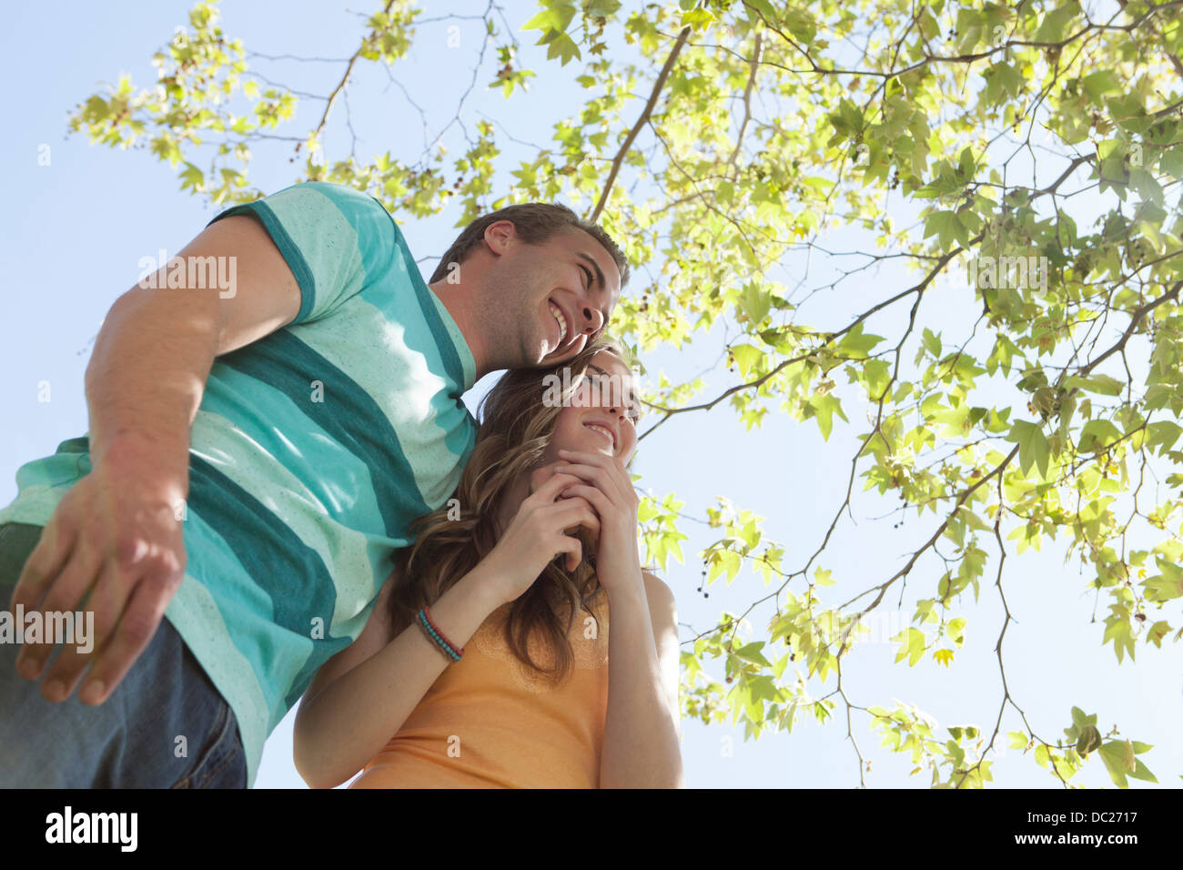 Couple under tree, low angle Stock Photo - Alamy