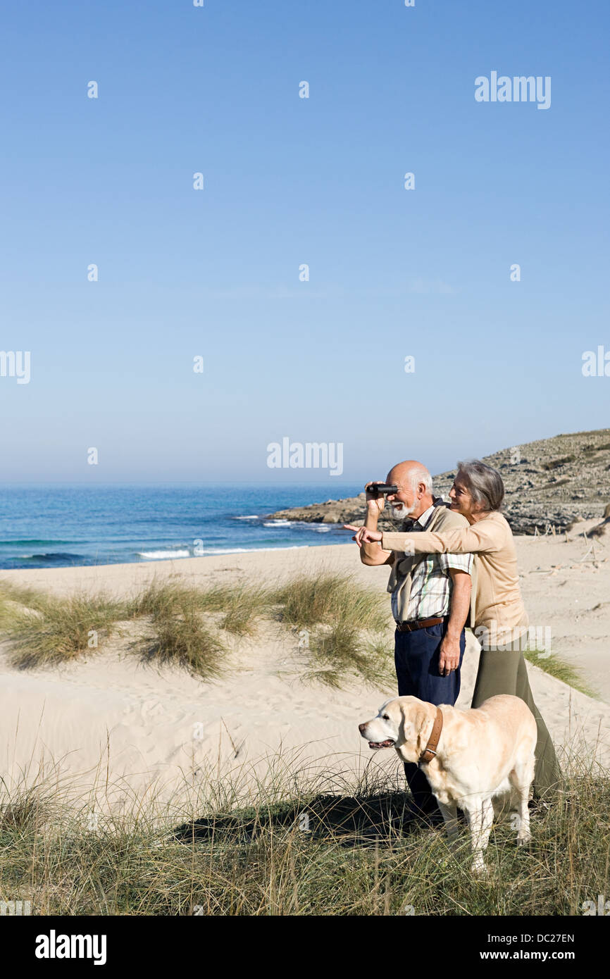 Senior couple using binoculars at beach Stock Photo - Alamy