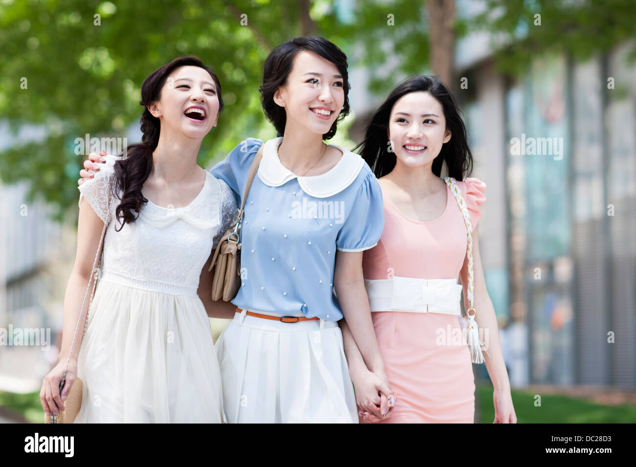 Happy female friends walking side by side Stock Photo - Alamy