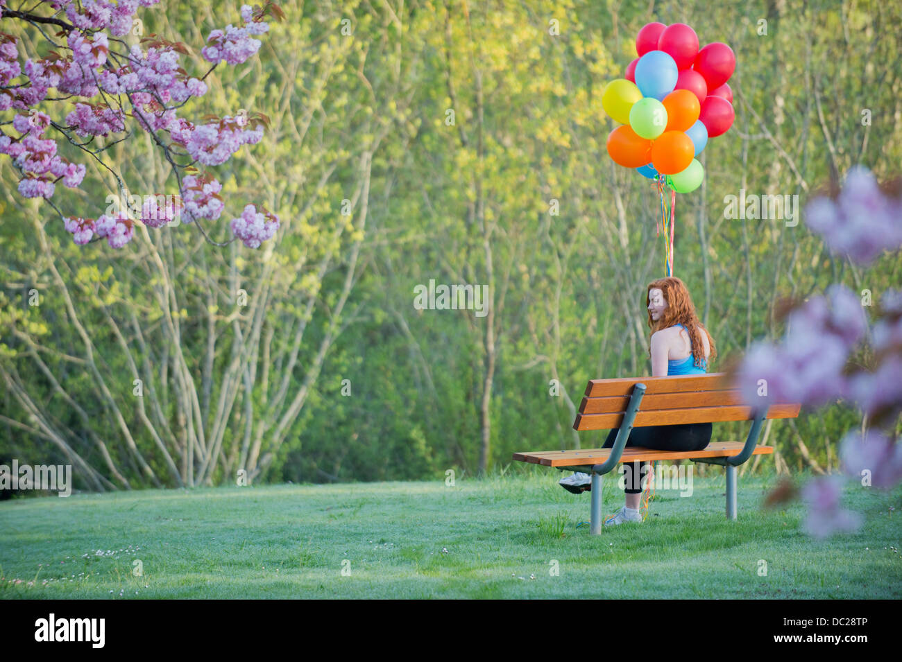 Teenage girl sitting on park bench with balloons Stock Photo - Alamy
