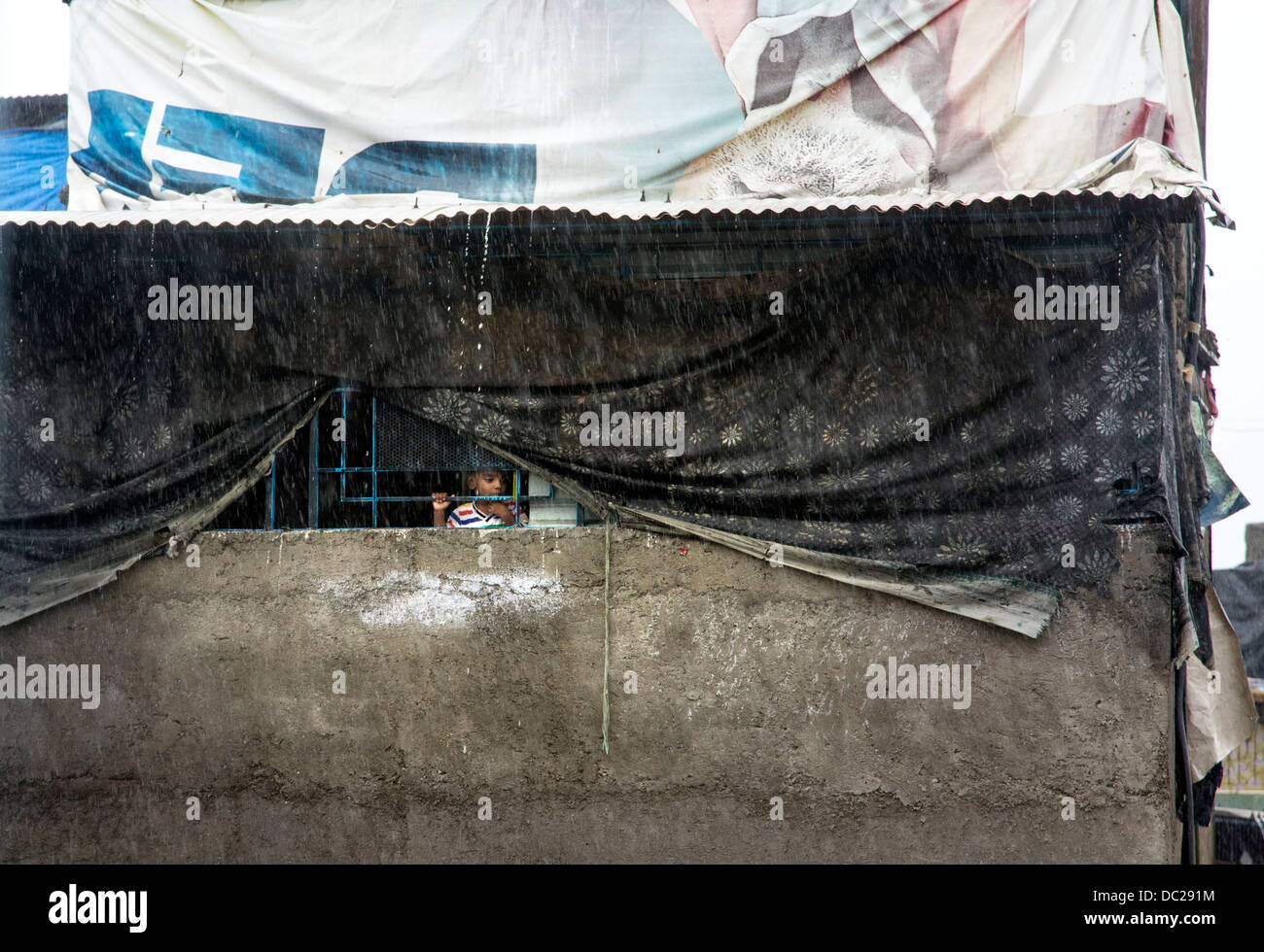 Boy looks out of slum building window dirty tarpaulin Stock Photo - Alamy