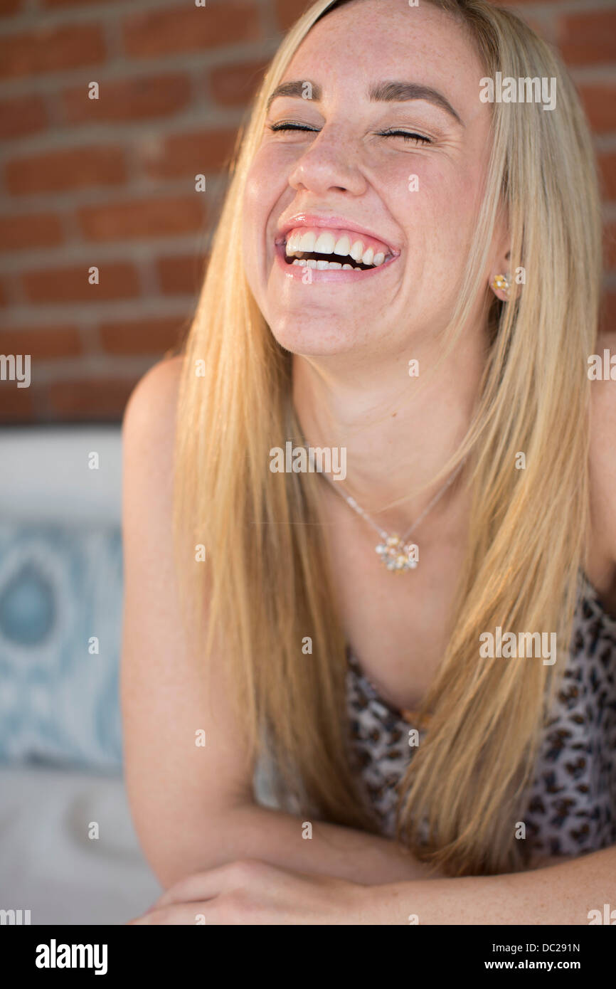Portrait of young woman with long blonde hair laughing Stock Photo - Alamy