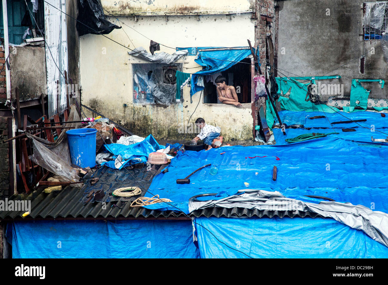 Slum buildings life children playing hanging out of window held by legs ...