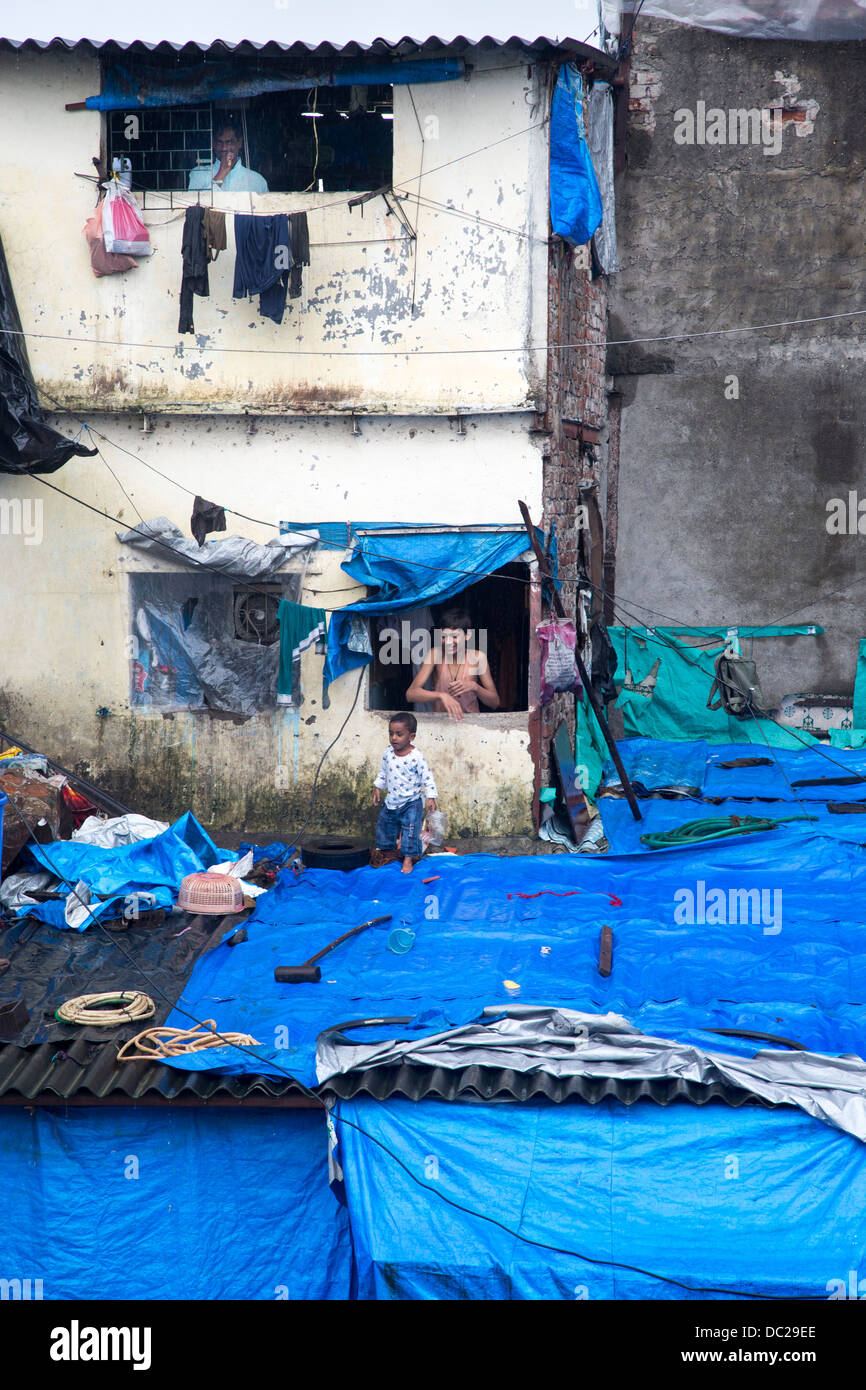 Slum buildings life children playing hanging out of window held by legs ...